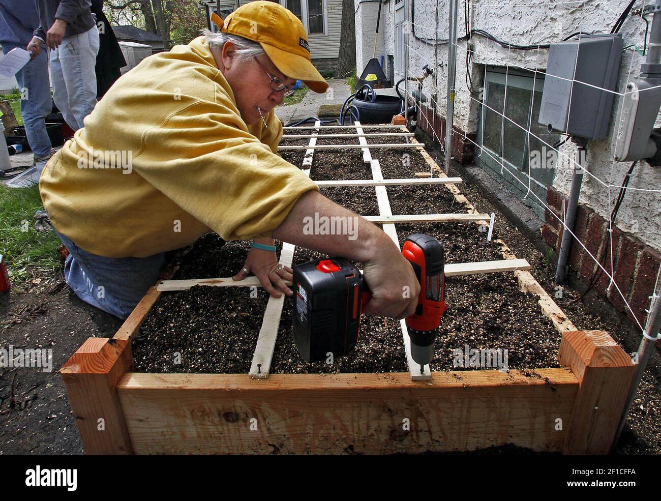 Joan James, co-owner of A Backyard Farm, works on building the ...