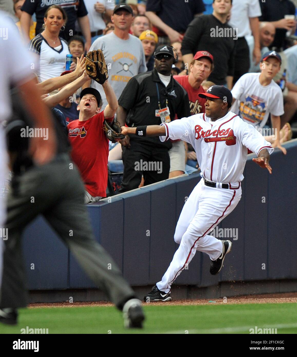 Atlanta Braves left fielder Garret Anderson tangles with a fan while ...