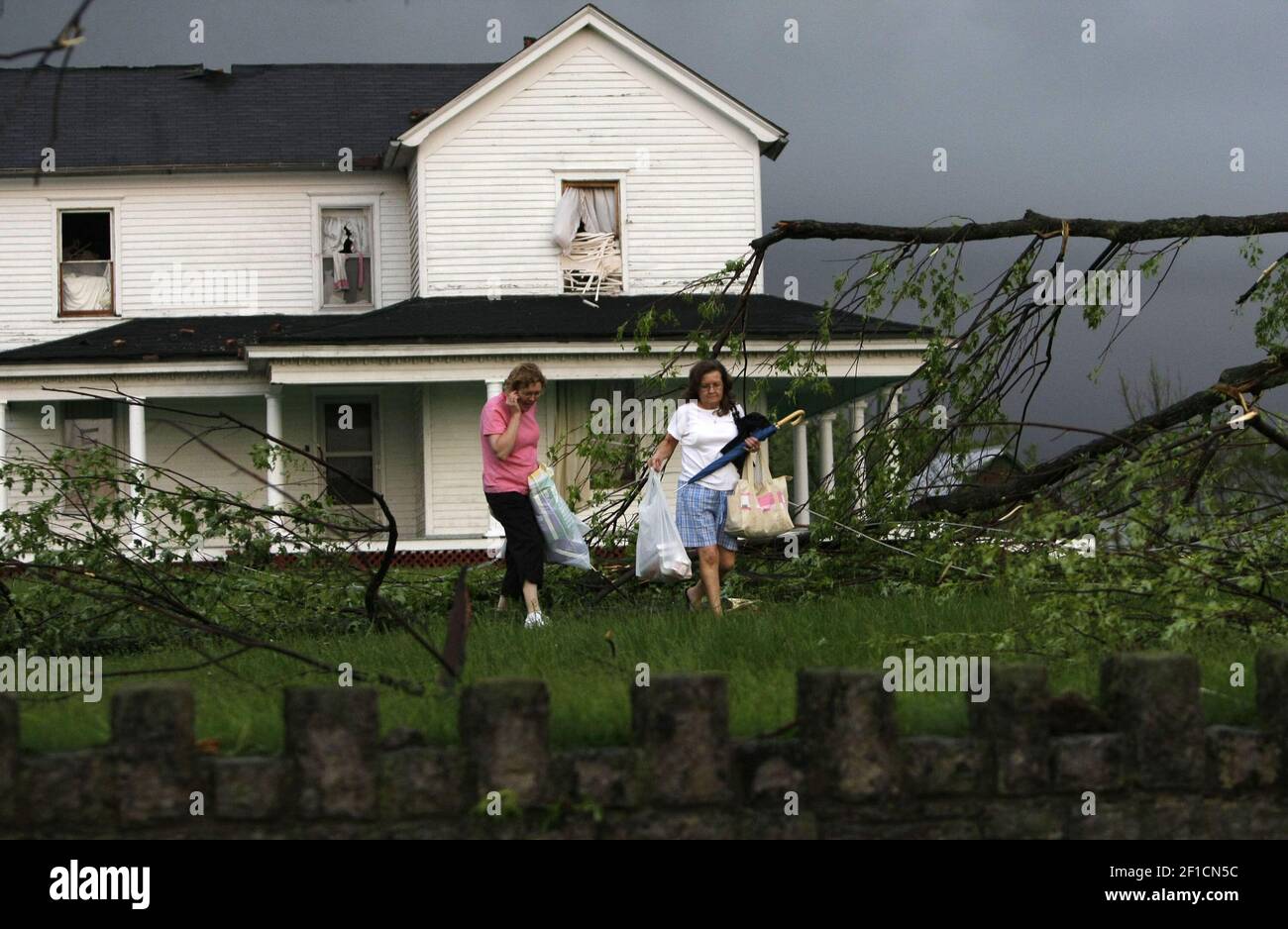 Amanda Johnson, left, and Betty Collins evacuate after strong storms ...