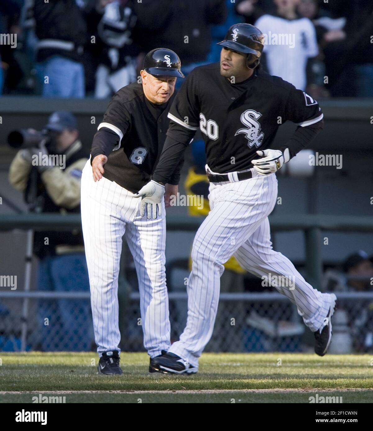 Chicago White Sox third base coach Jeff Cox, left, congratulates Carlos ...