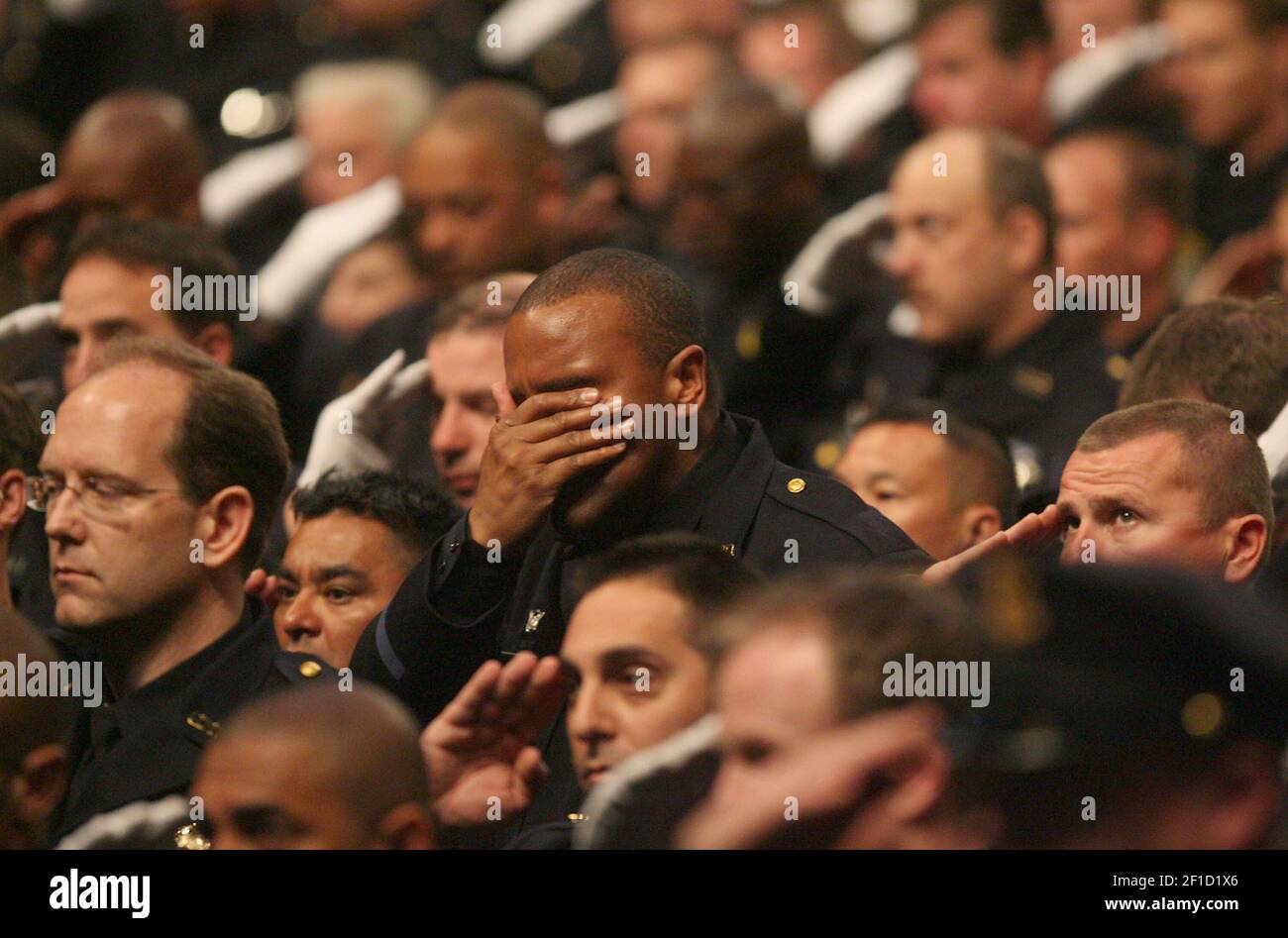 An Oakland police officer is overcome with grief on Friday, March 27 ...