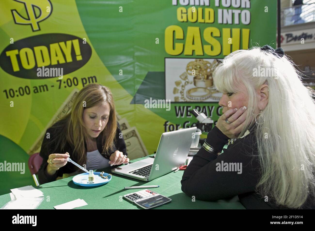 Lyssa King, left, owner of Gold Buyers based in Appleton, test a gold ...