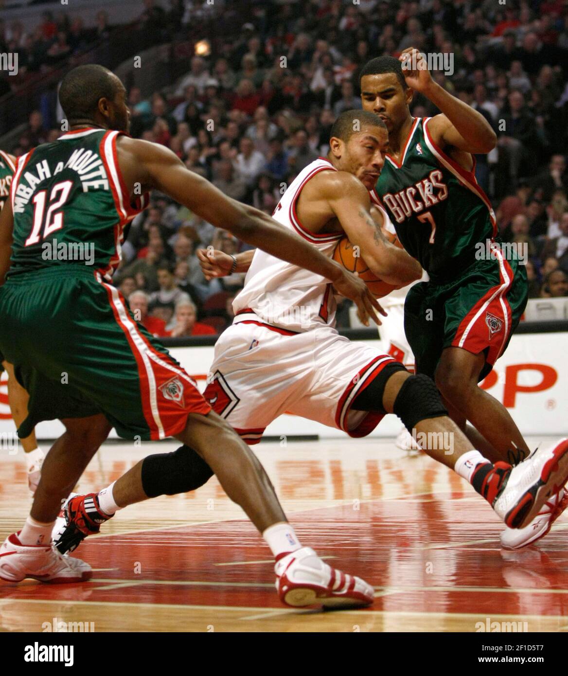 Chicago Bulls Derrick Rose slides past Milwaukee Buck defenders Luc ...