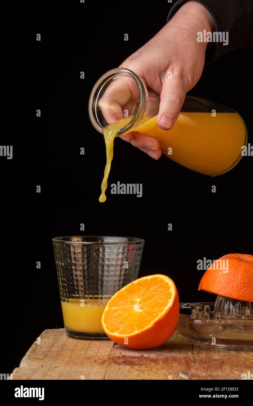 View of woman's hand serving frozen orange juice with a bottle, over a ...