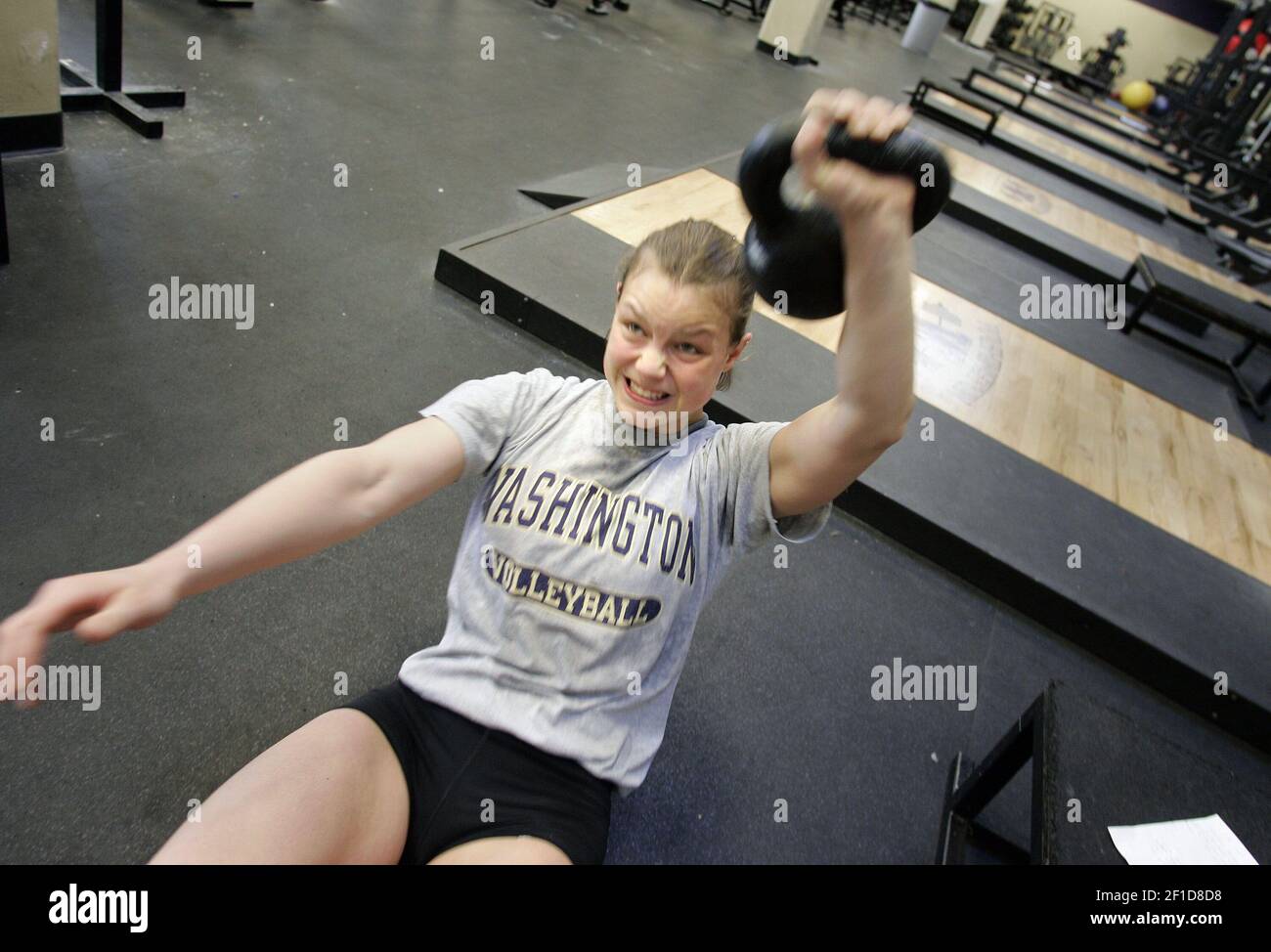 Holding a weight for resistance, Courtney Thompson does sit-ups to ...