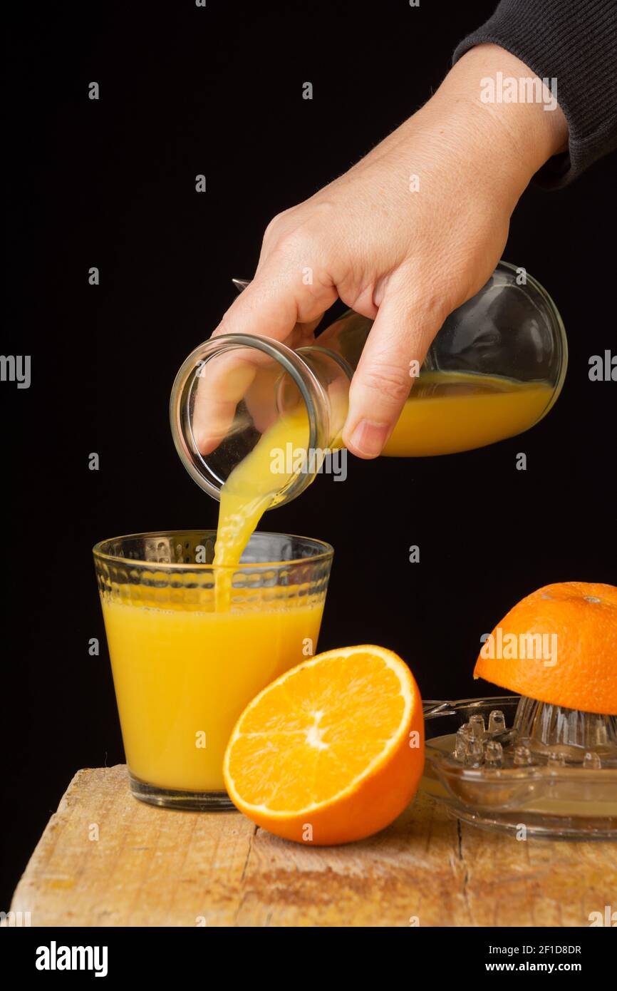 Close-up of woman's hand serving frozen orange juice with a bottle ...