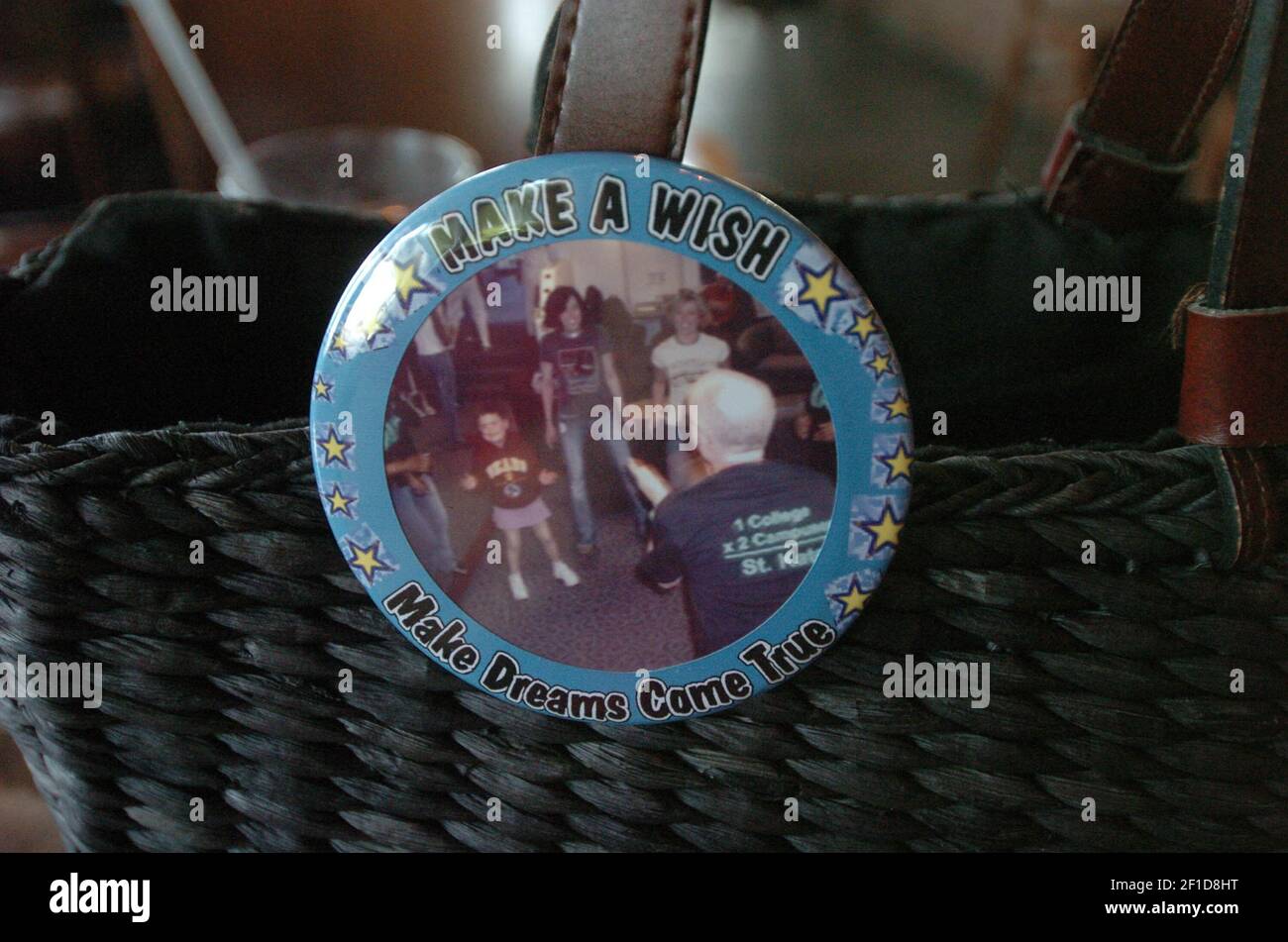 Sue Woodcock wears a Make-A-Wish button on her purse with a photo of ...