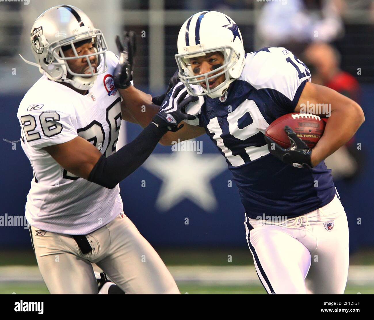 Miles Austin of the Dallas Cowboys fends off Stanford Routt of the ...