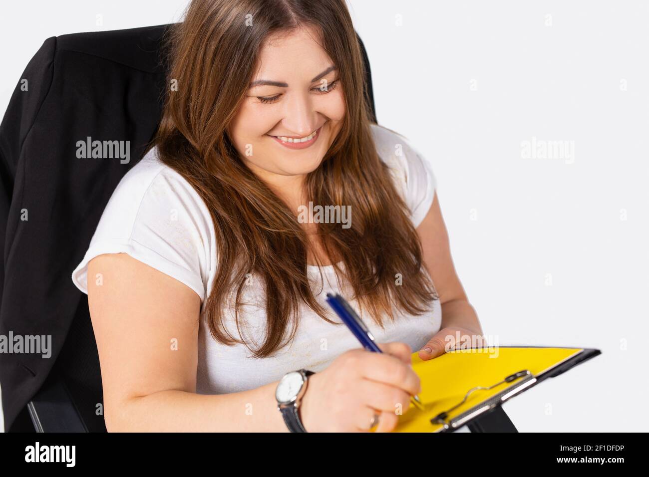 Overweight model, successful businesswoman take note on clipboard with ...