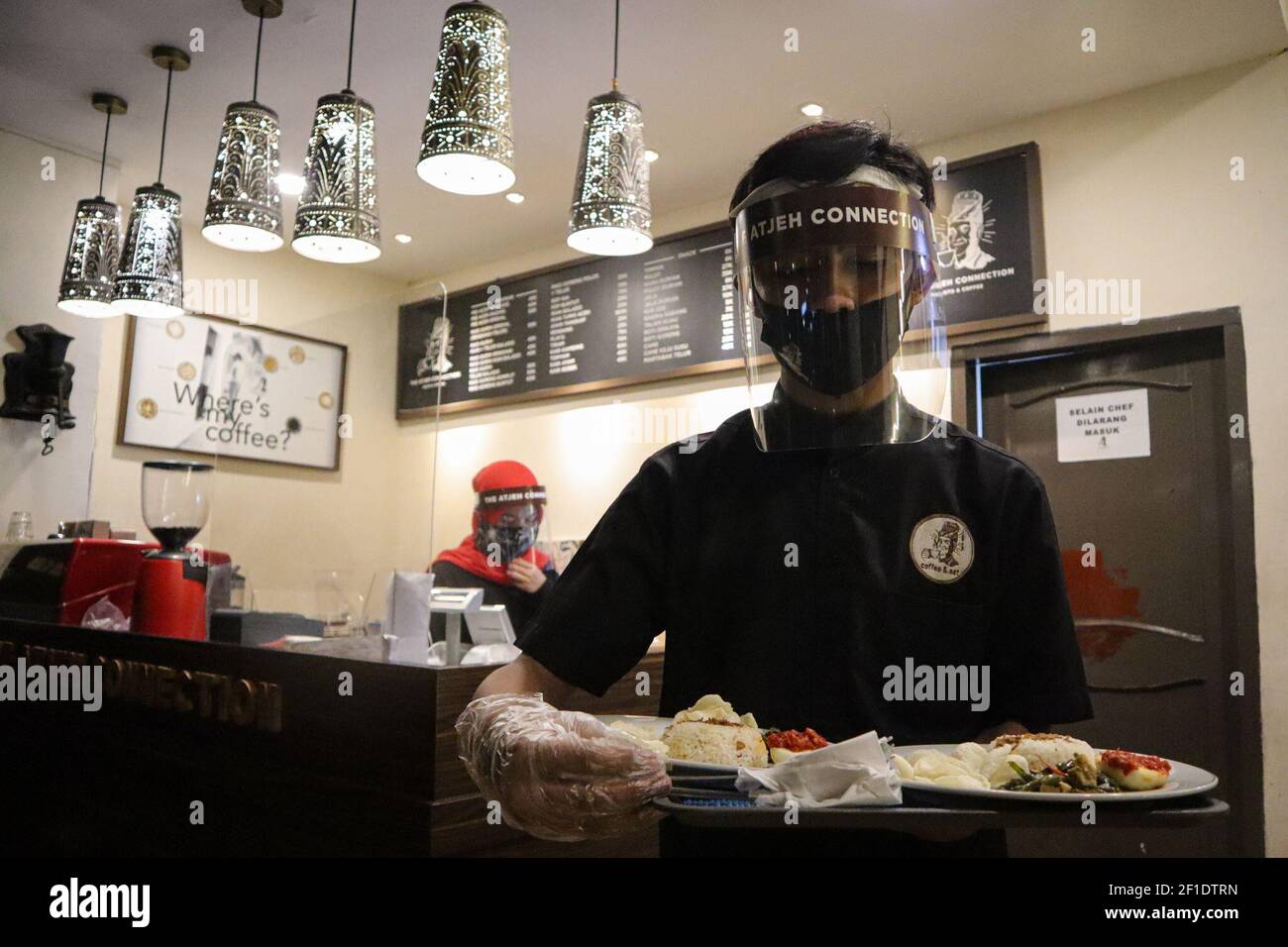 A Waitress wears face shield serves a food for costumer at the Atjeh ...
