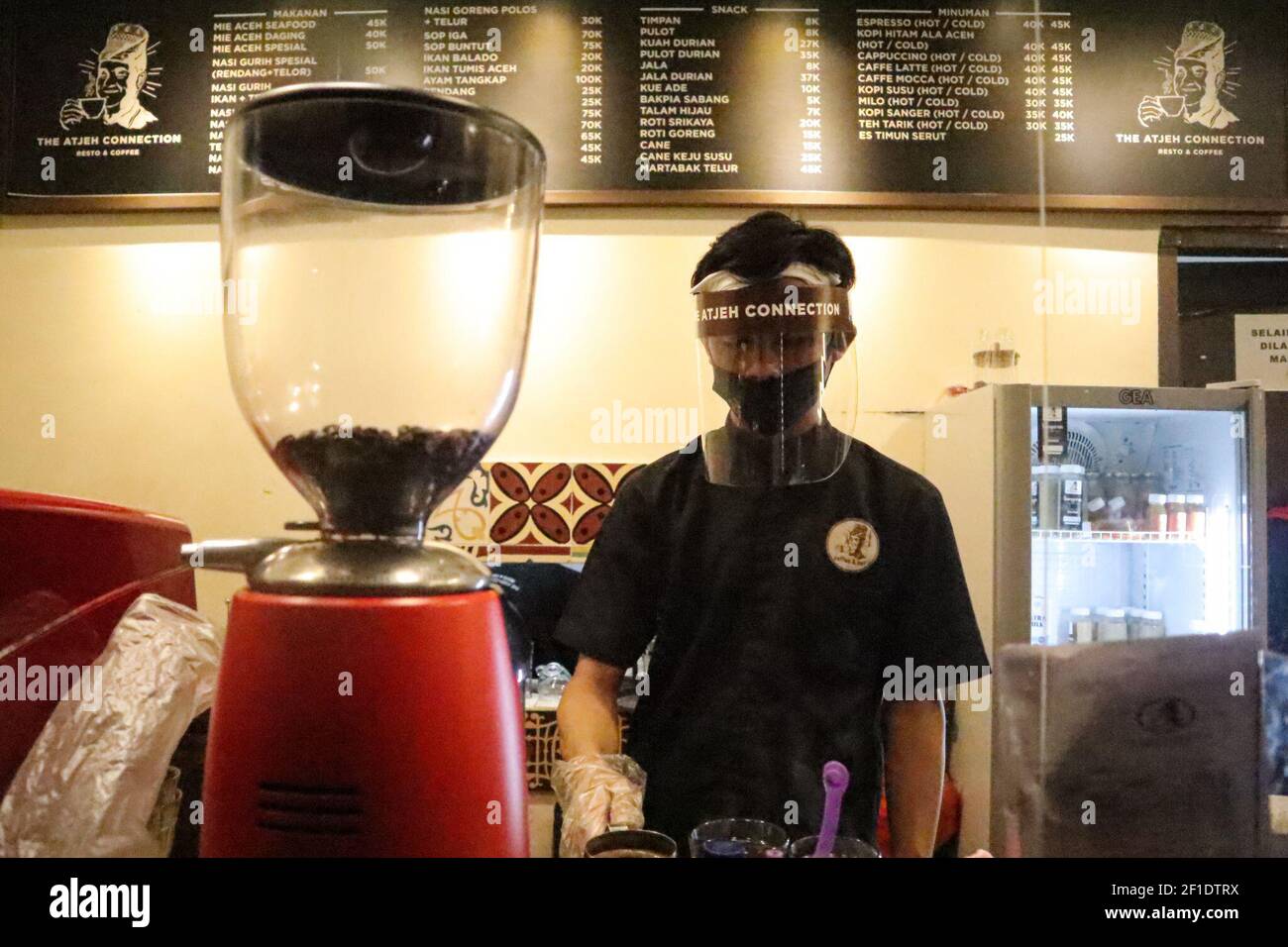 A employee wears face shield as preventive measure, at the Atjeh ...