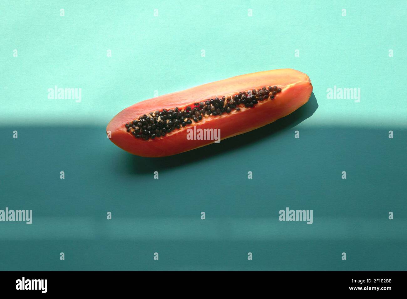 Slice of papaya on blue background with shadow. Trendy summer vibes ...