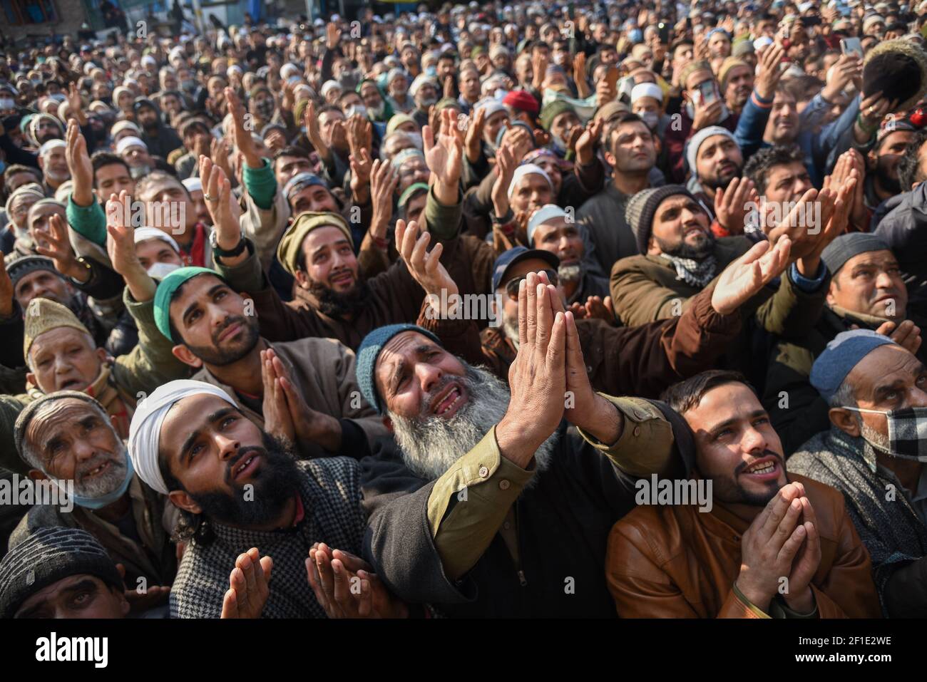 Kashmiri Muslim devotees raise hands while beseeching for blessings as ...