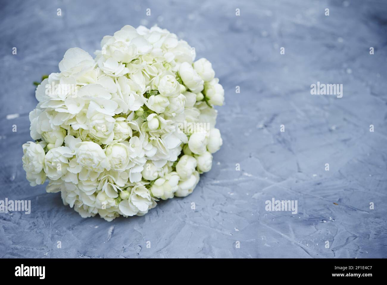 A gentle bouquet of beautiful white Hydrangea flowers on a rough ...