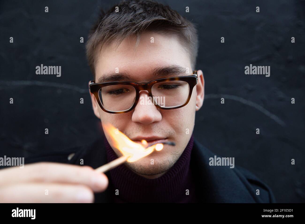 European young white man with a match close-up portrait isolated on ...