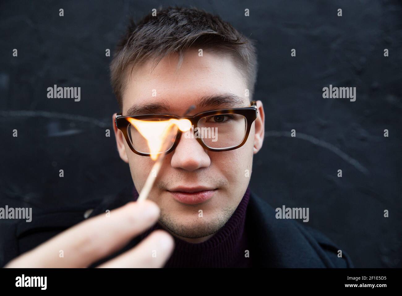 European young white man with a match close-up portrait isolated on ...