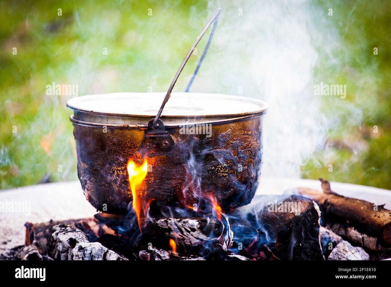 Cooking hot food over open fire outdoors in the forest Stock Photo - Alamy