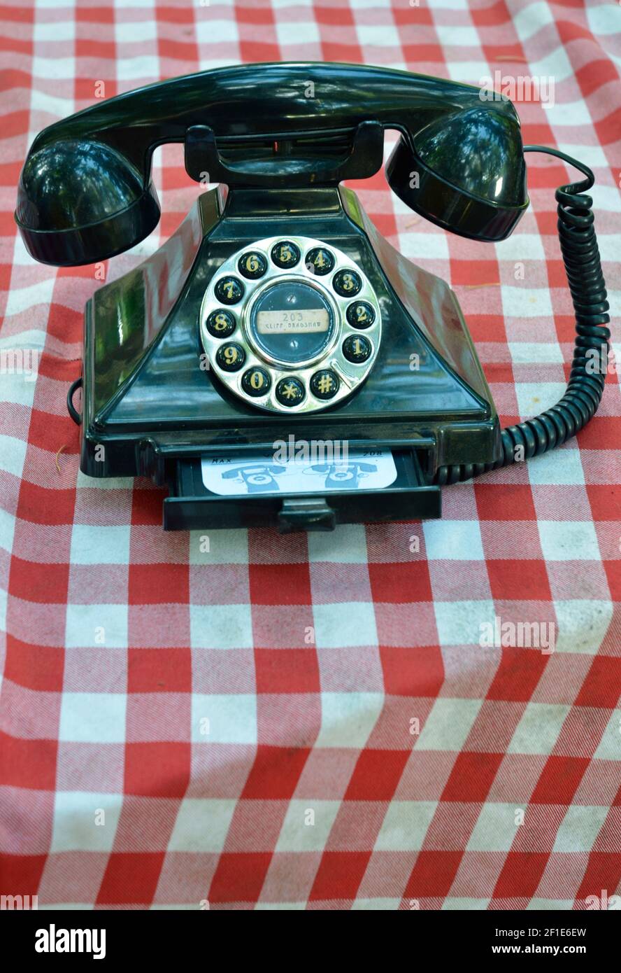 old school dial telephone on red check tablecloth Stock Photo - Alamy