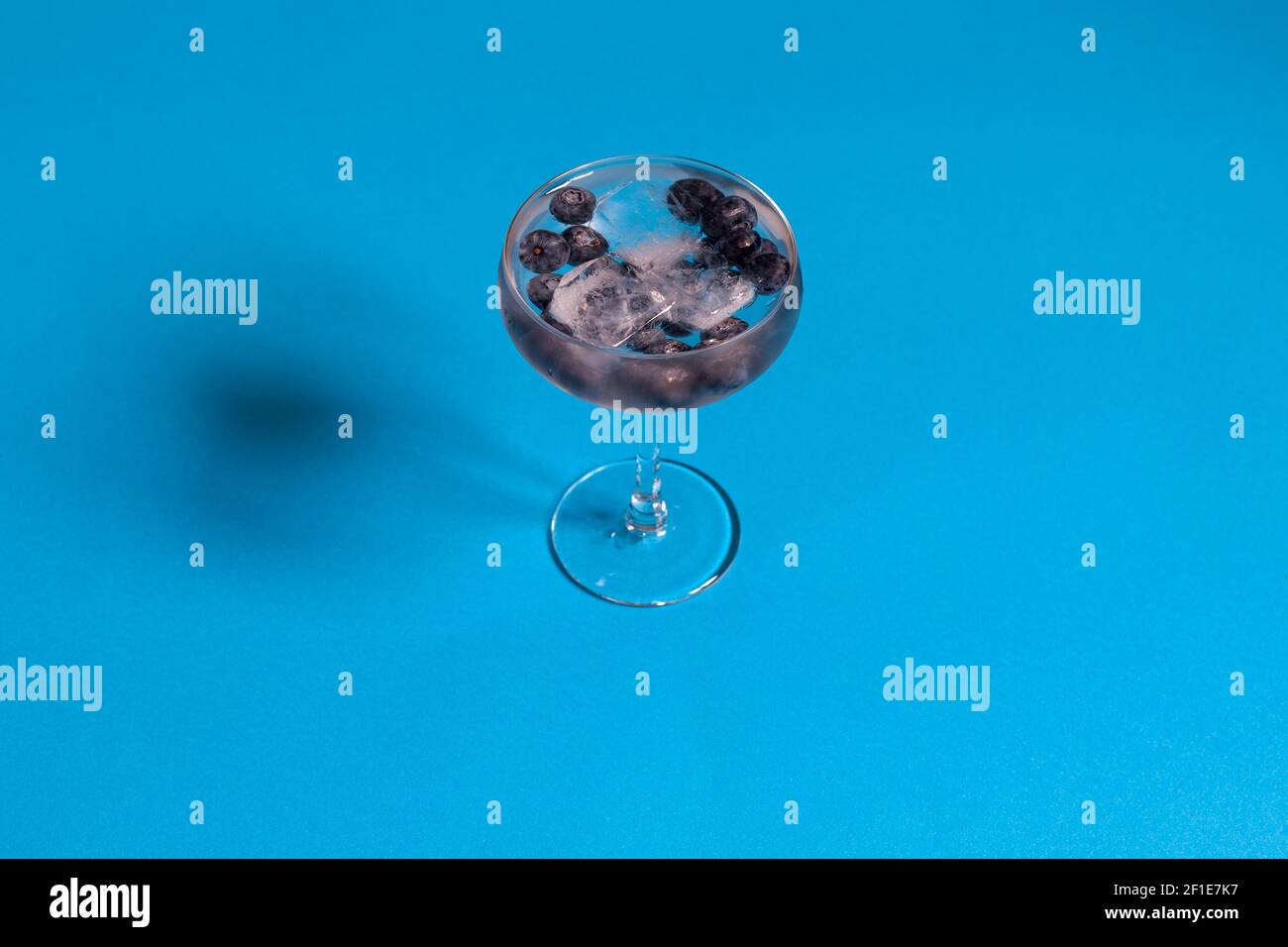 Clear cocktail with ice and blueberries Stock Photo - Alamy