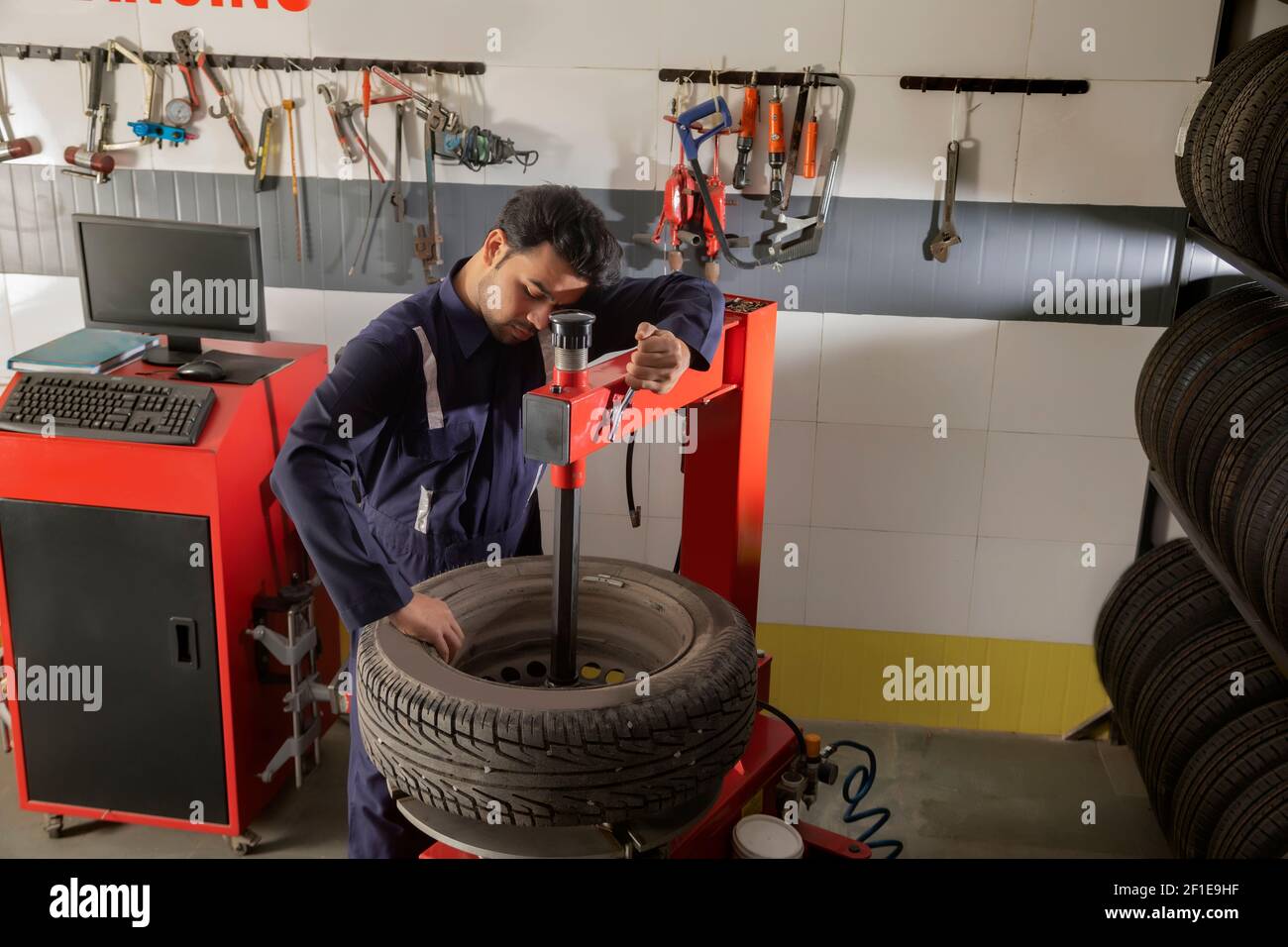 Technician working on a tyre changer a tyre shop Stock Photo - Alamy