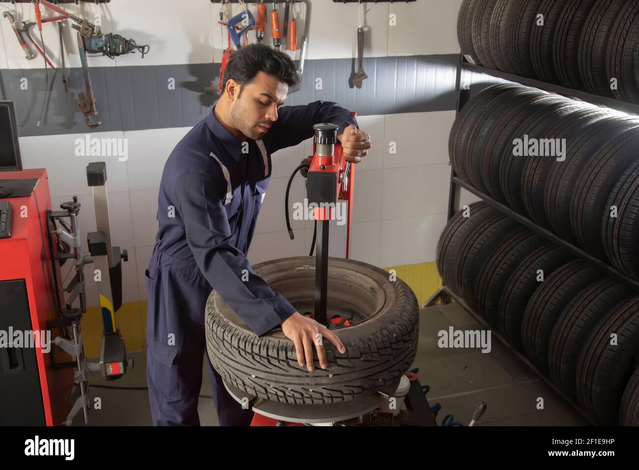 Technician working on a tyre changer a tyre shop Stock Photo - Alamy