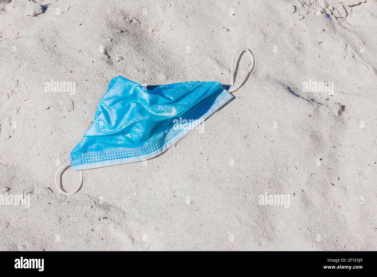 Used discarded medical protective mask on the beach sand. Sea beach ...