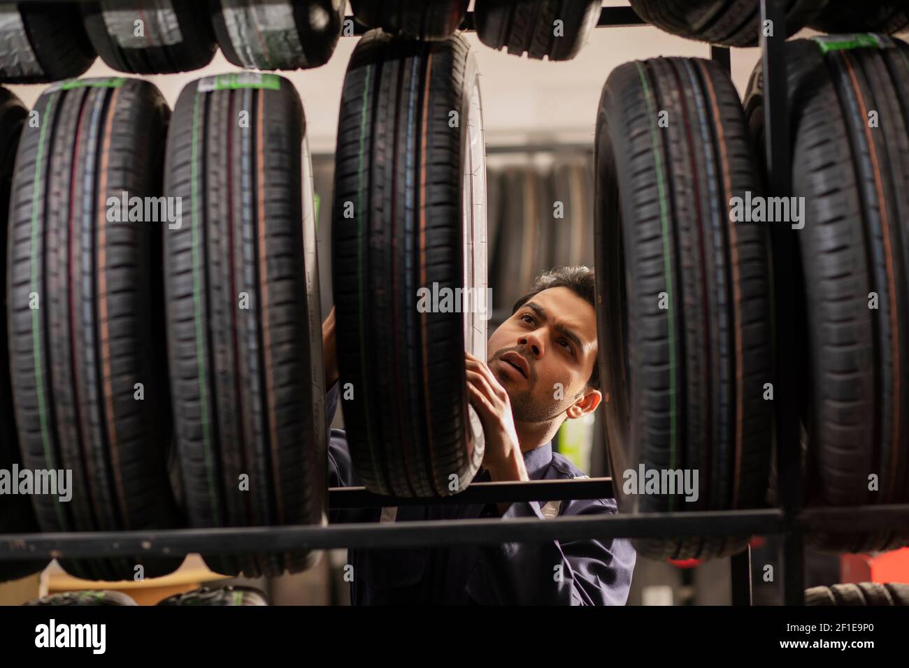 Technician selecting tyres in a tyre shop Stock Photo - Alamy