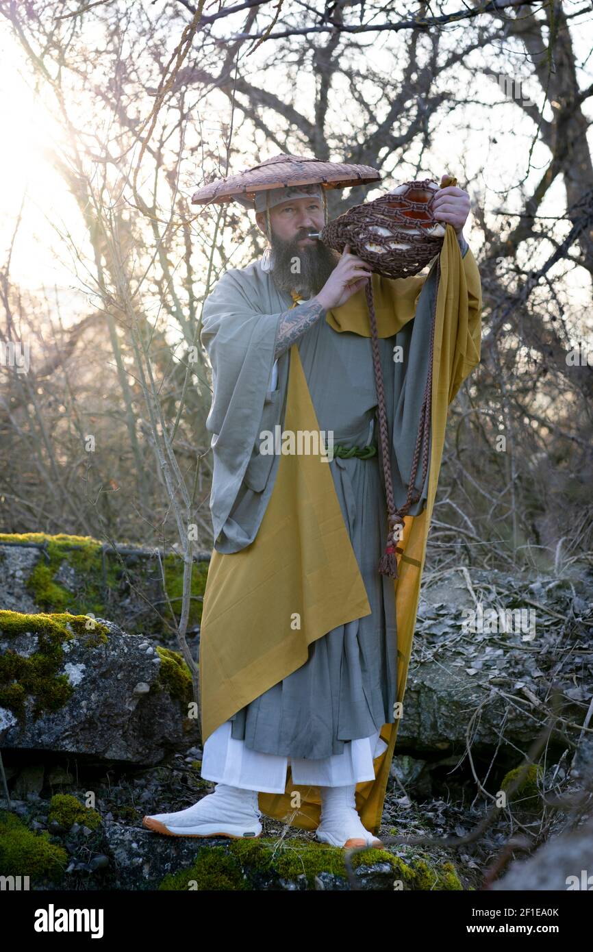 European man with beard blowing the conch in traditional, Japanese ...