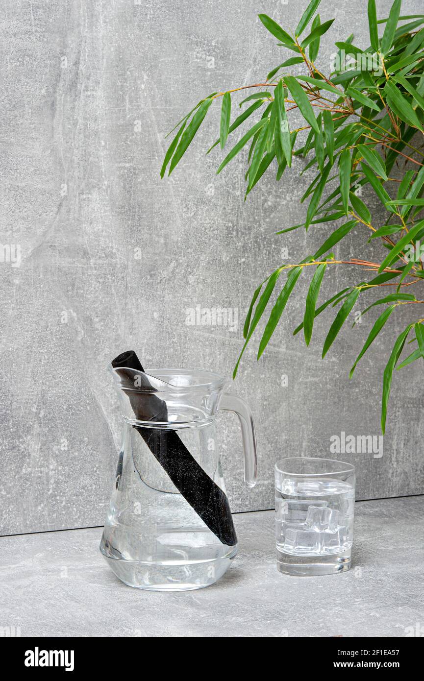 Bamboo charcoal water filter stick, green leaf and glass of water ...