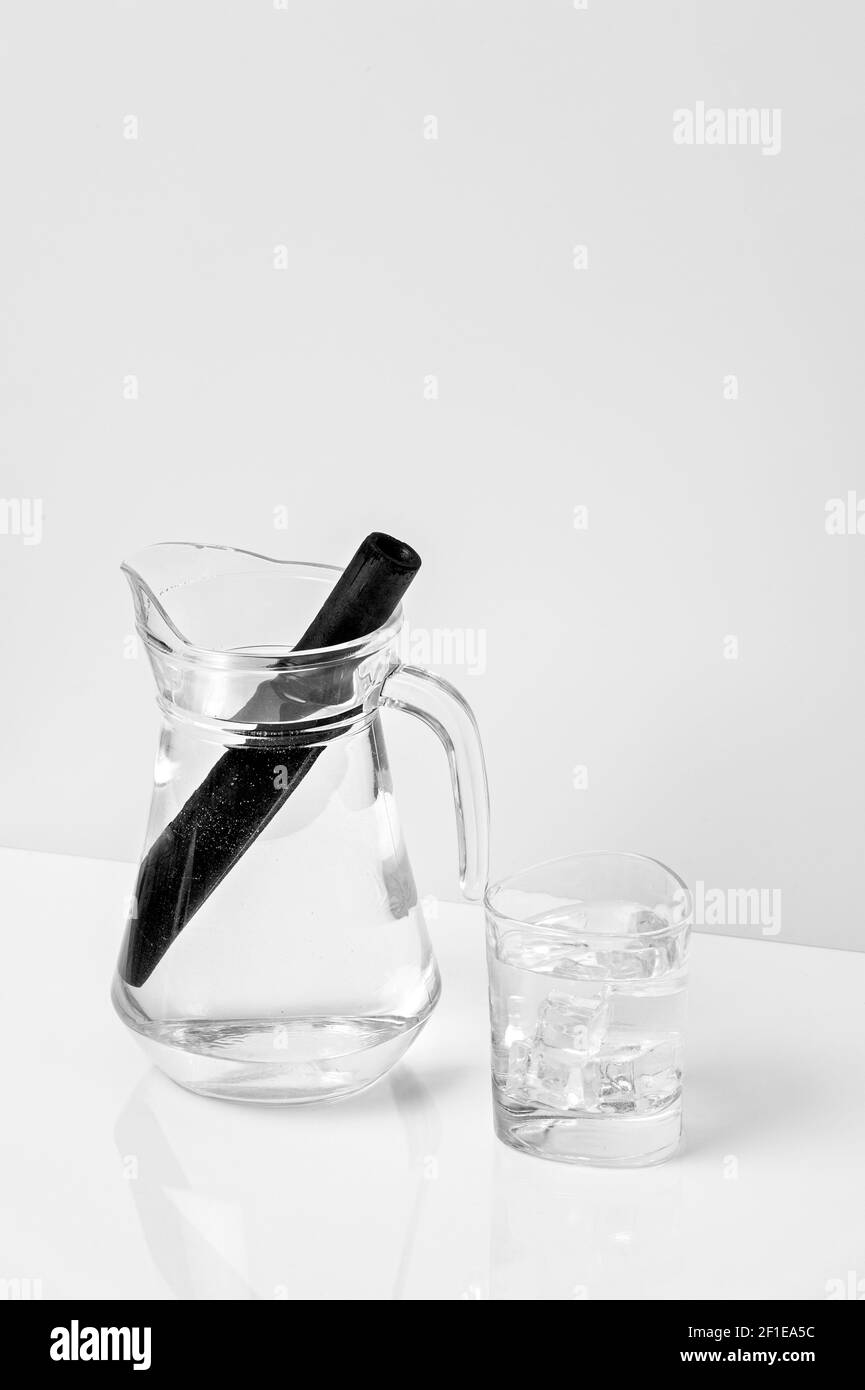 Bamboo charcoal water filter stick and glass of water. Natural bamboo ...