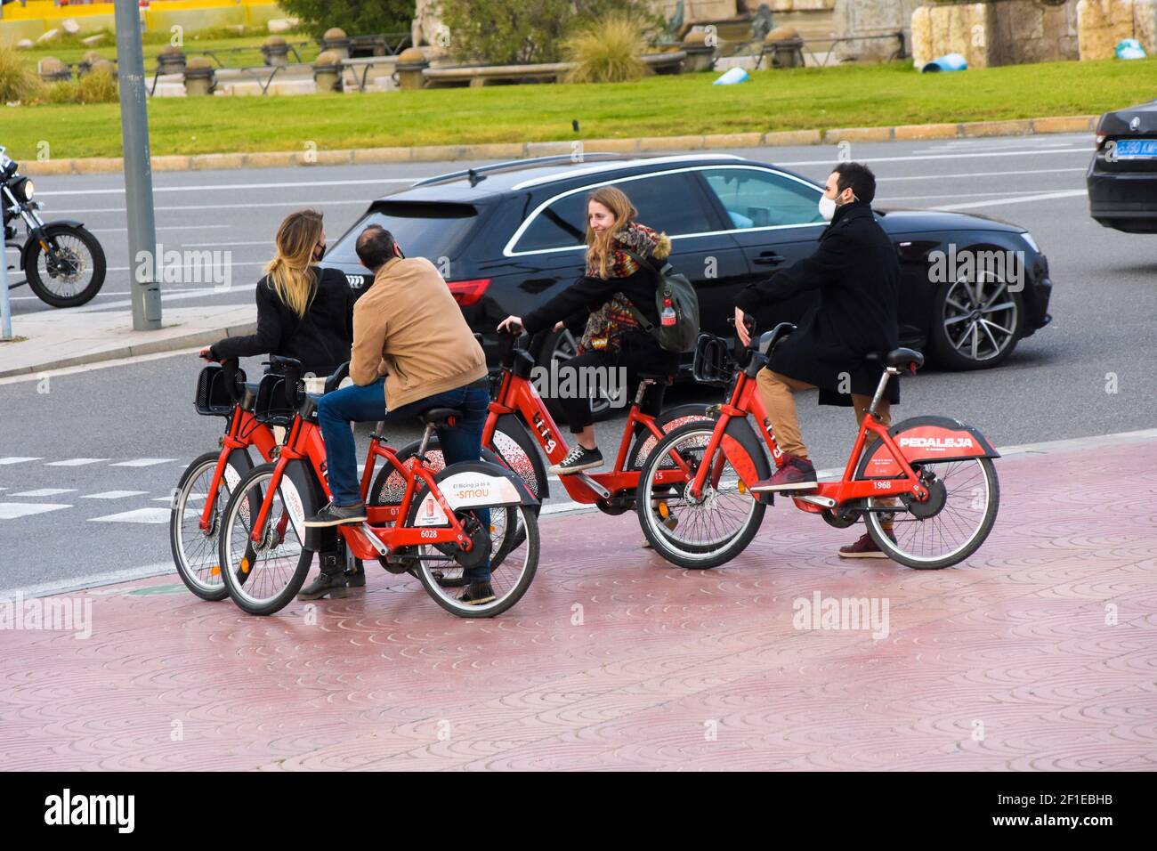 Group of people riding Bicing bikes waiting in a stop light. Real ...
