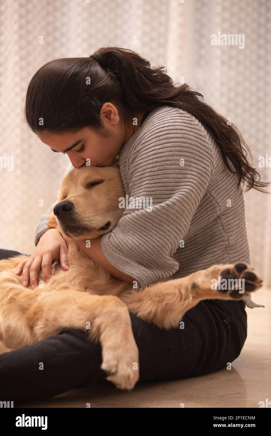 A TEENAGER HUGGING AND KISSING PET DOG WHILE AT HOME Stock Photo - Alamy