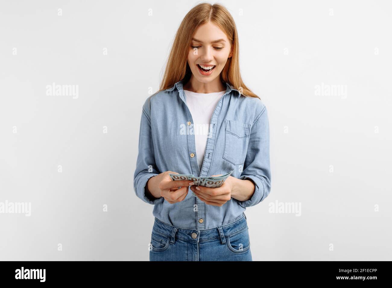 Happy young purposeful woman counting money over isolated white ...