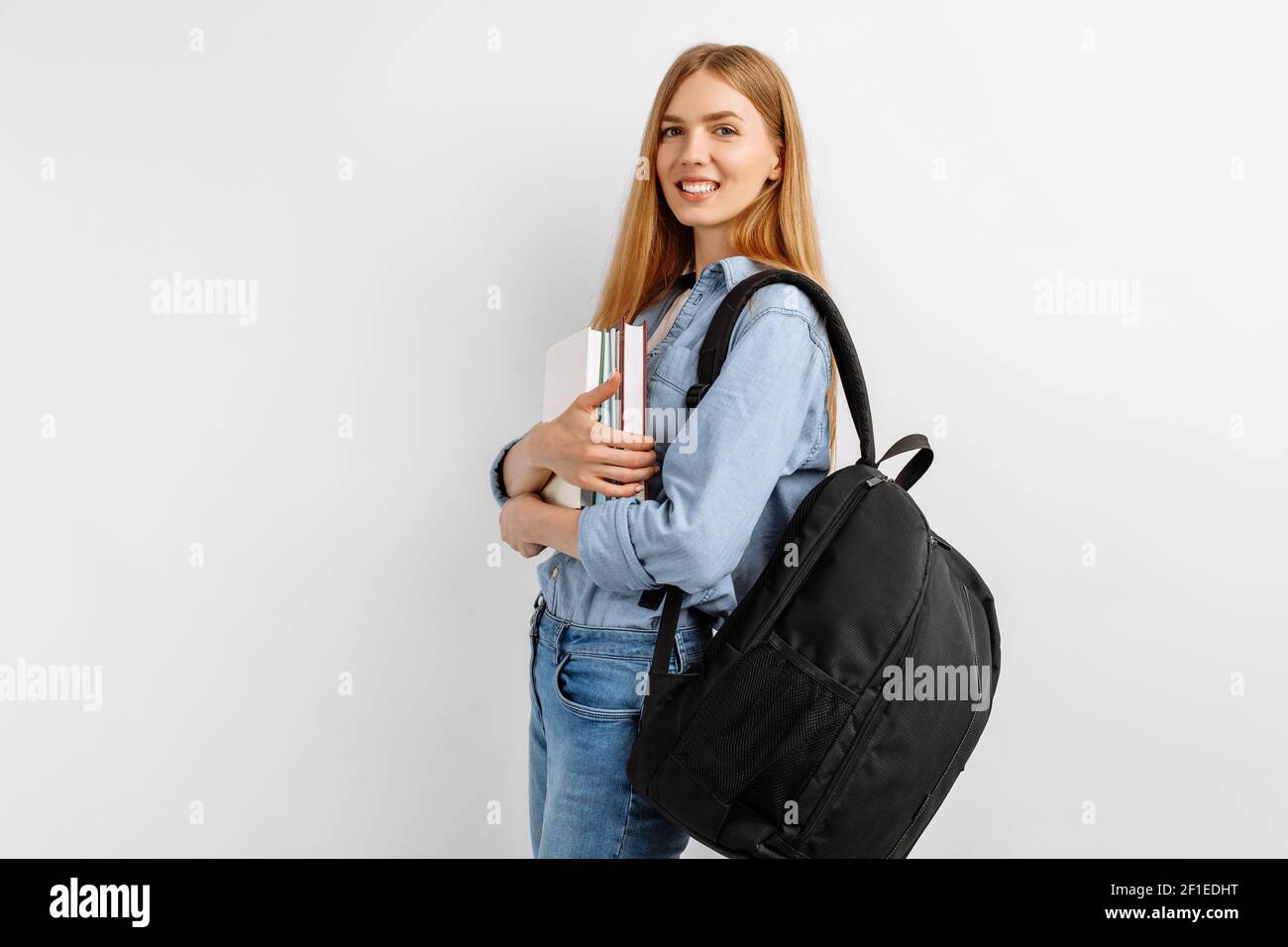 Portrait of smiling college student girl, with books and backpack on ...
