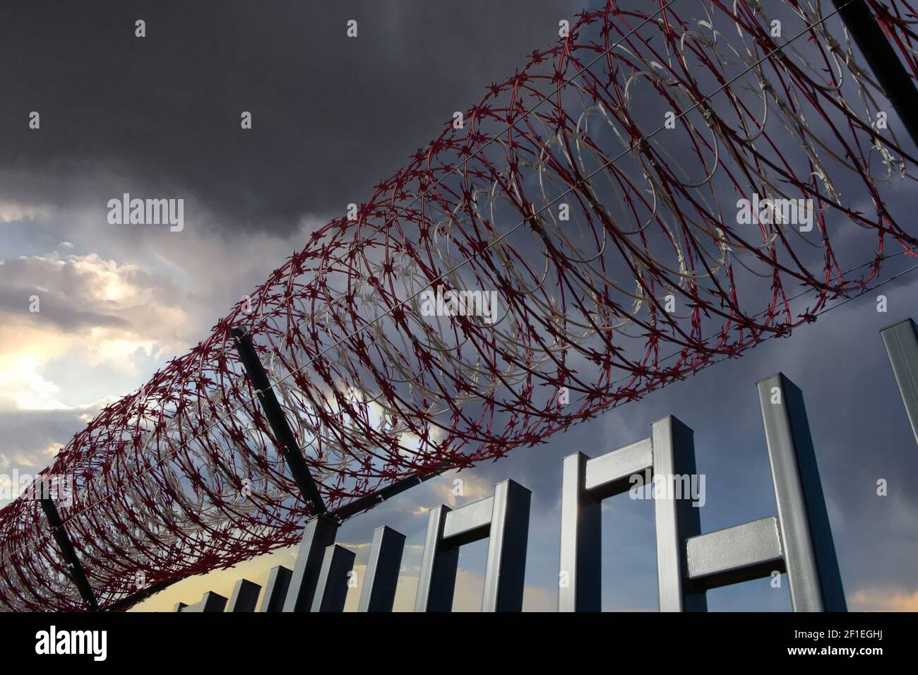 Coil of razor barbed wire as barricade against trespasser on a gloomy ...