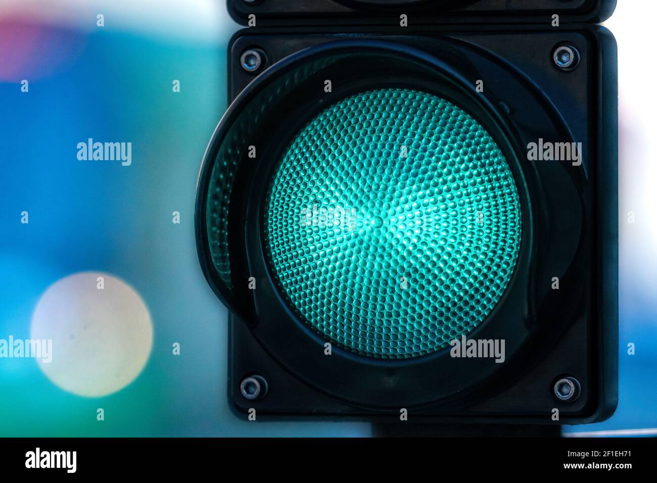 closeup of traffic semaphore with green light on defocused city street ...