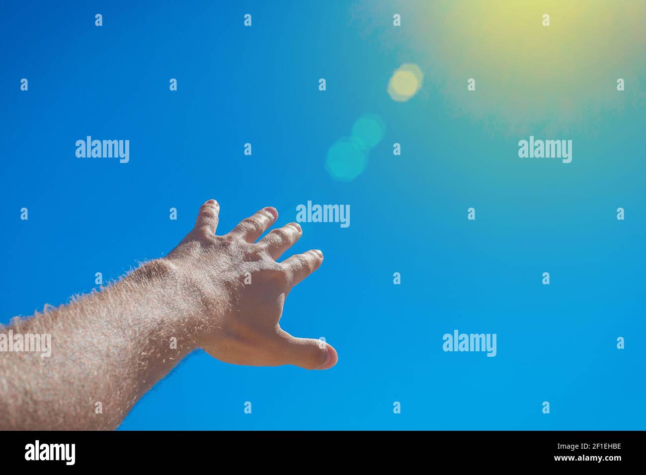 The guy stretched his hand forward towards the blue sky and the sun ...