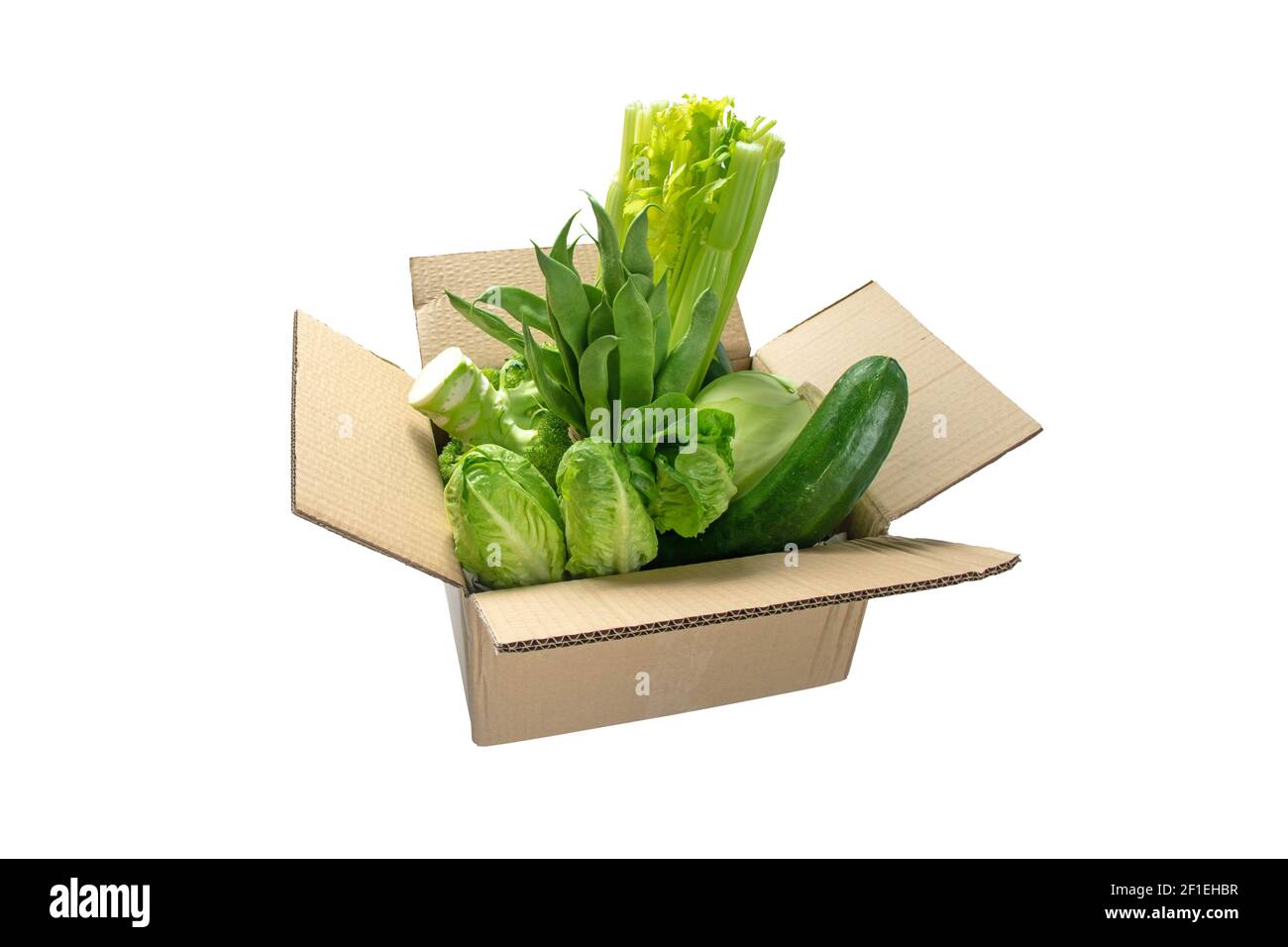 Green colored vegetables in the cardboard box isolated on white. Food ...