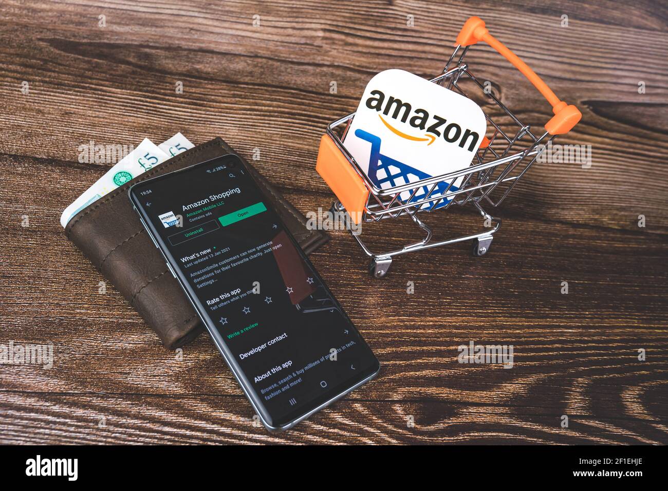 Amazon logo in mini shopping trolley, app on Google Play on smartphone ...
