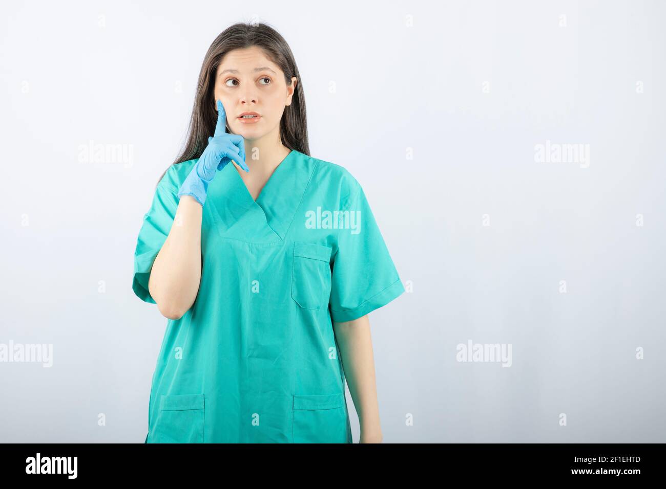 Image of a pensive young female nurse standing and looking away Stock ...