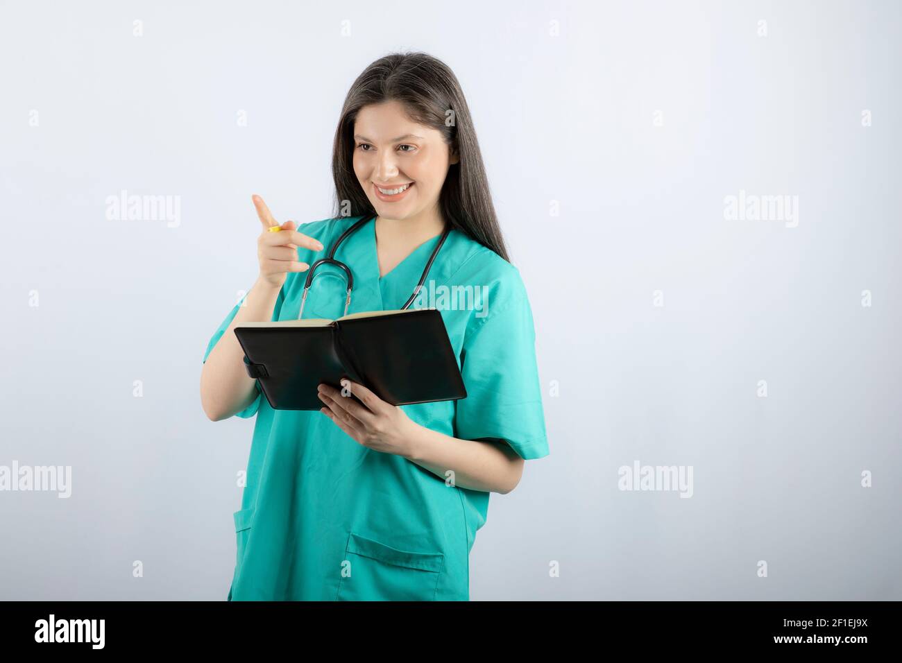 Photo of a young female doctor standing with notebook and pencil Stock ...