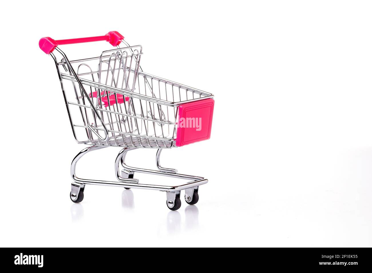 An empty supermarket cart with pink details stands on a white ...
