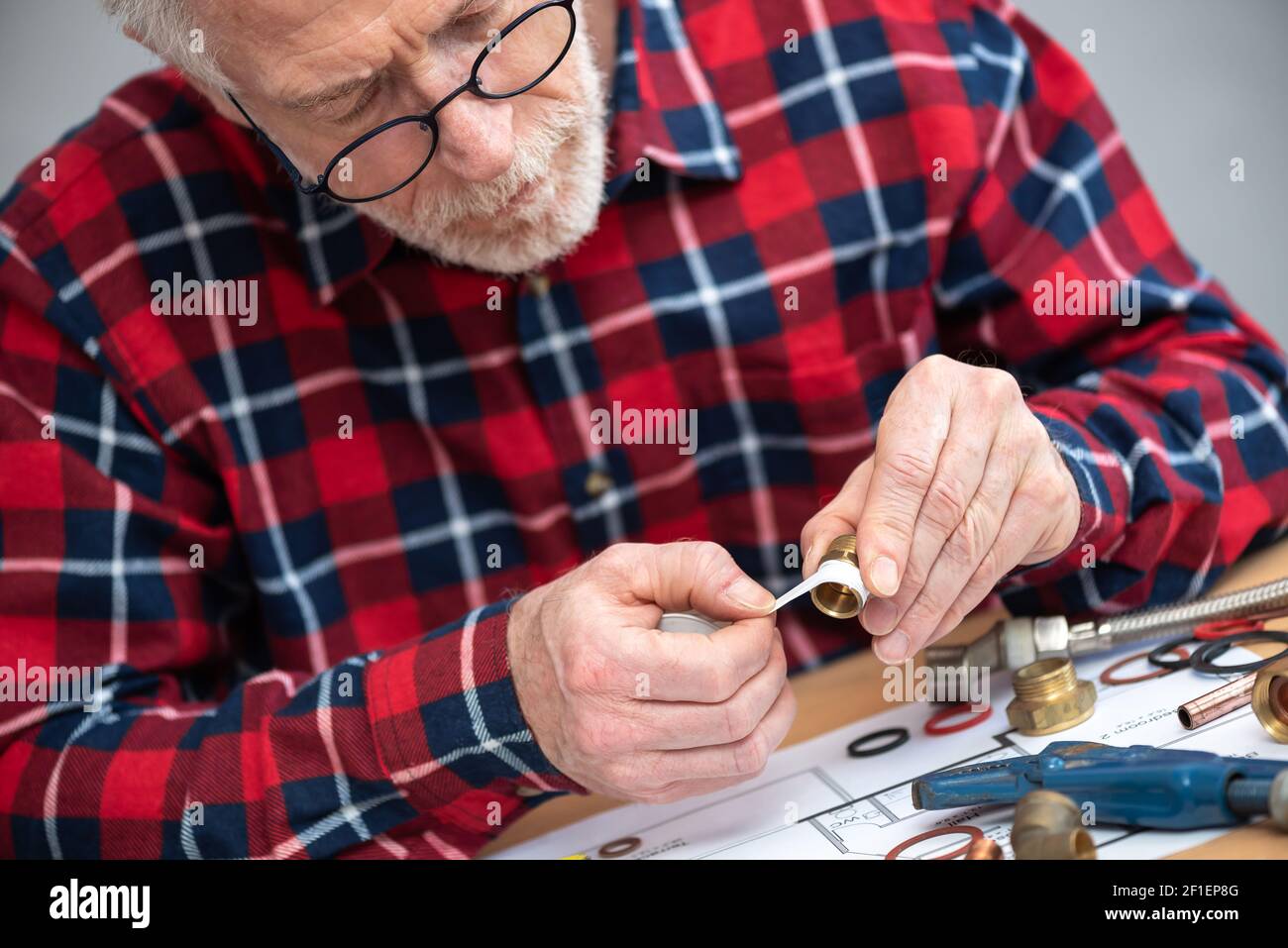 Plumber putting seal tape on a thread of a plumbing fitting Stock Photo ...