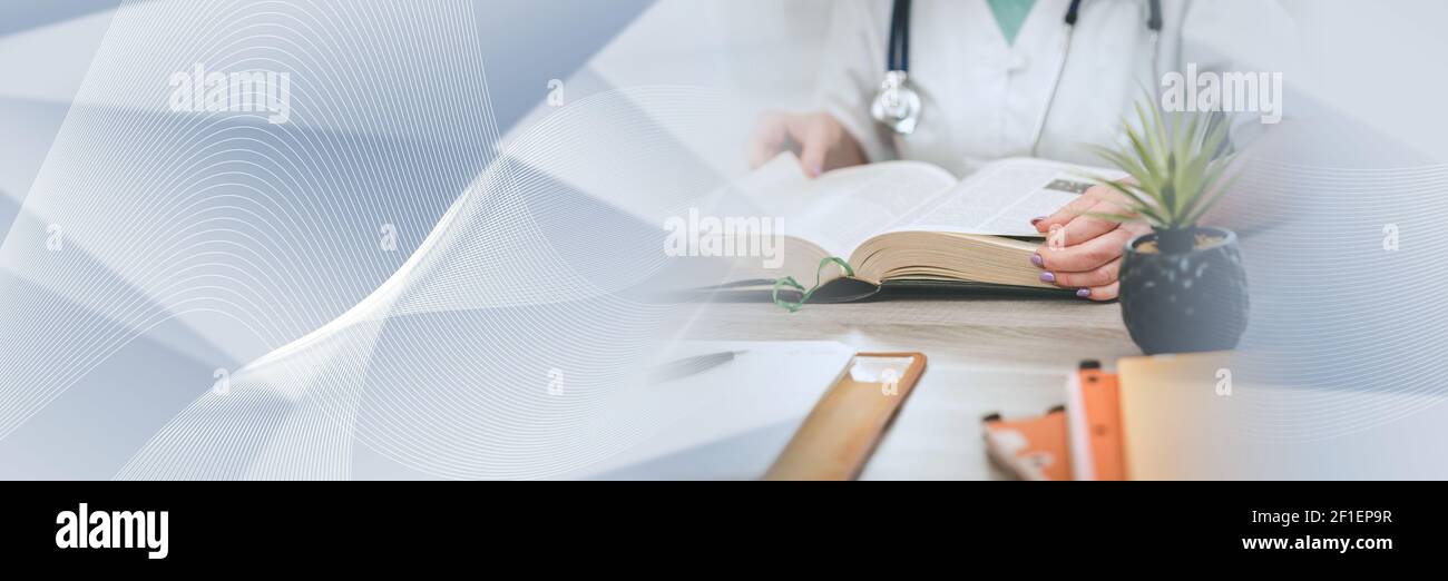 Female doctor reading a textbook in medical office; panoramic banner ...