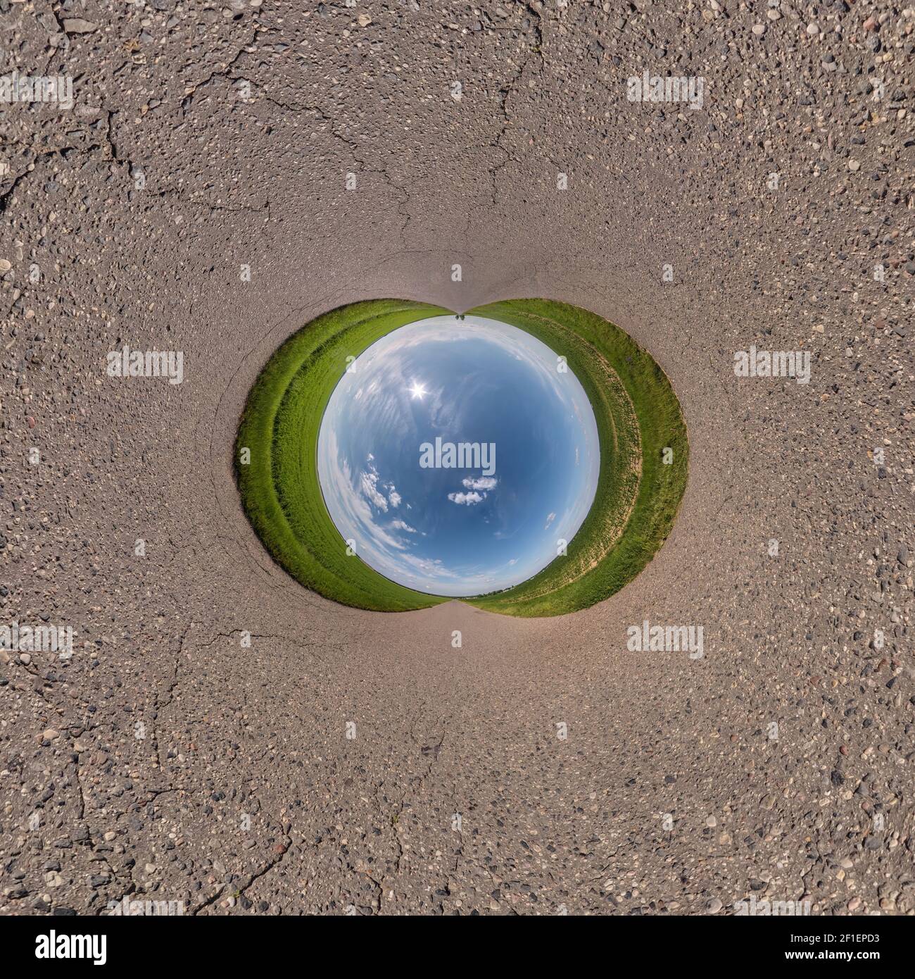 blue sky ball in middle of swirling asphalt road. Inversion of tiny ...