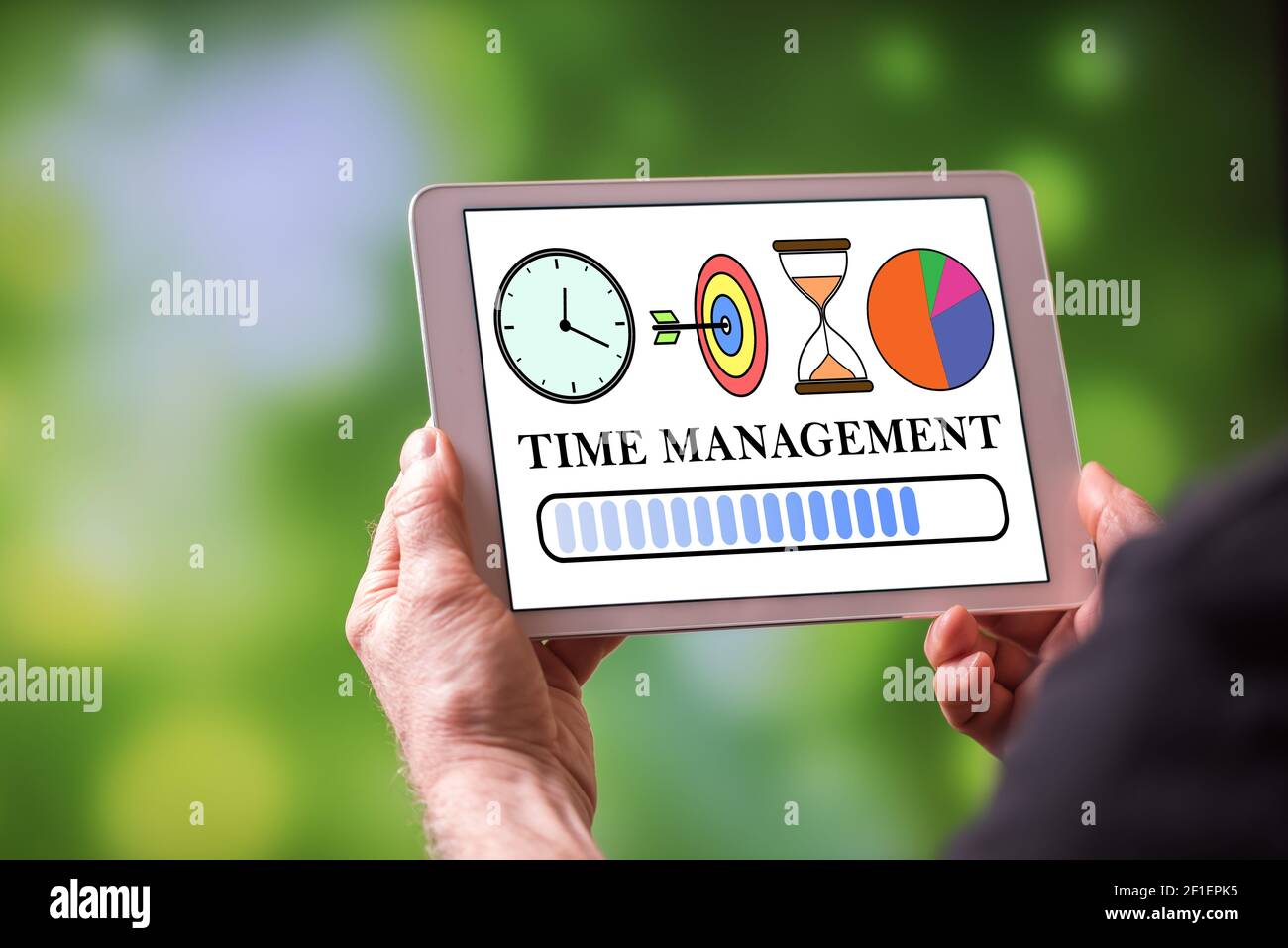 Man holding a tablet showing time management concept Stock Photo - Alamy
