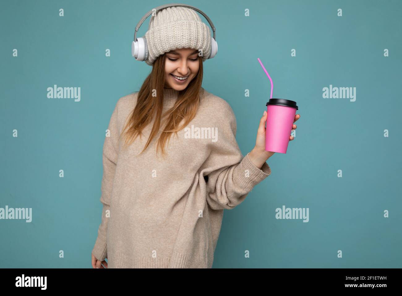 Charming happy smiling young blonde woman wearing beige winter sweater ...