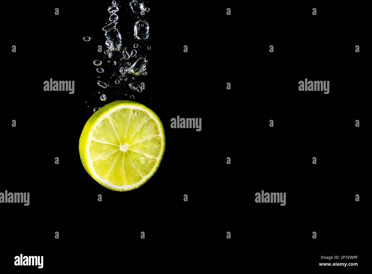 Lime falling into the water with air bubbles. Photo on black background ...
