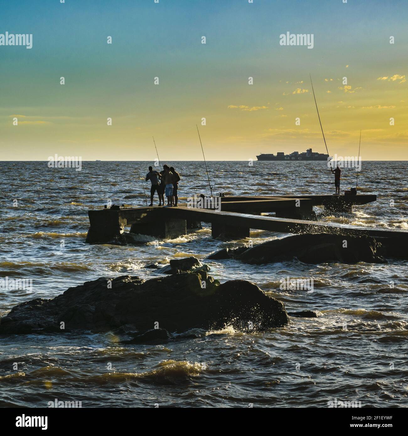 People Fishing at Breakwater of River Stock Photo - Alamy