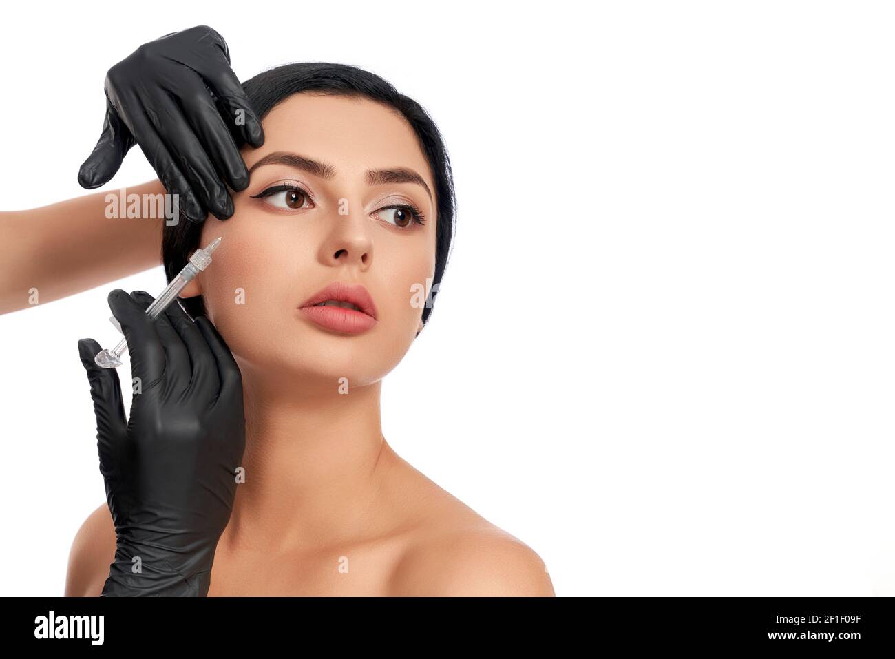 Portrait of stunning young brunette having beauty injection with ...